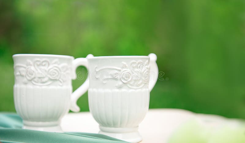 Two White Empty Cups on Table Against Green Background. Stock Photo ...