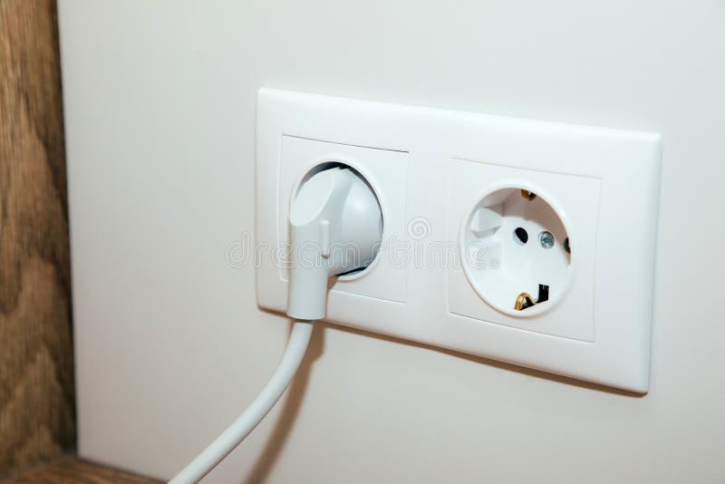 Two White European Electrical Sockets with an Insert Plug on a White ...