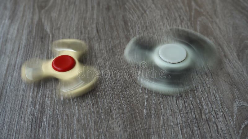 Two White Hand Spinner Spinning on Grey Background or Fidget Spinners ...