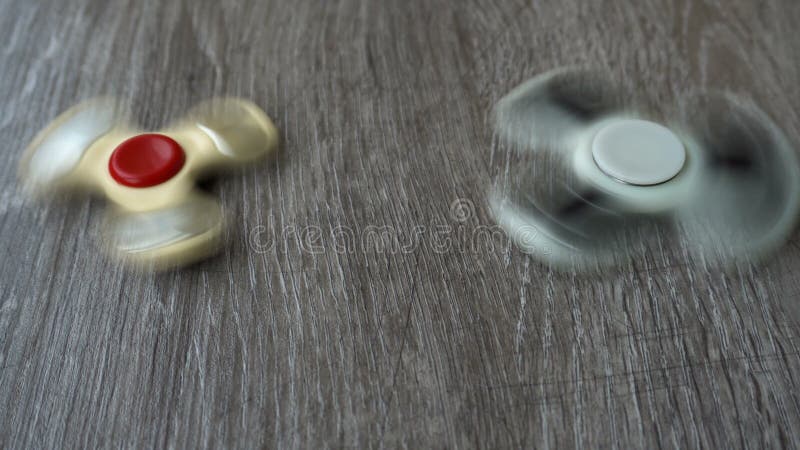 Two White Hand Spinner Spinning on Grey Background or Fidget Spinners ...