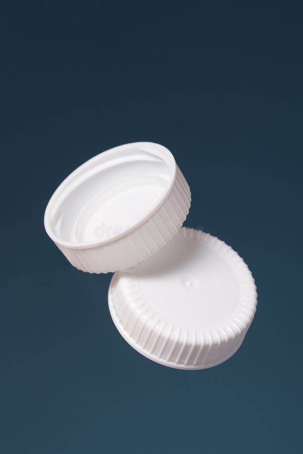 Two White Plastic Bottle Caps on a Blue Background. Front and Back of ...