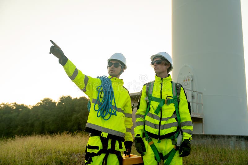 Two of Wind Turbine or Windmill Workers or Technician Stand on Base of ...