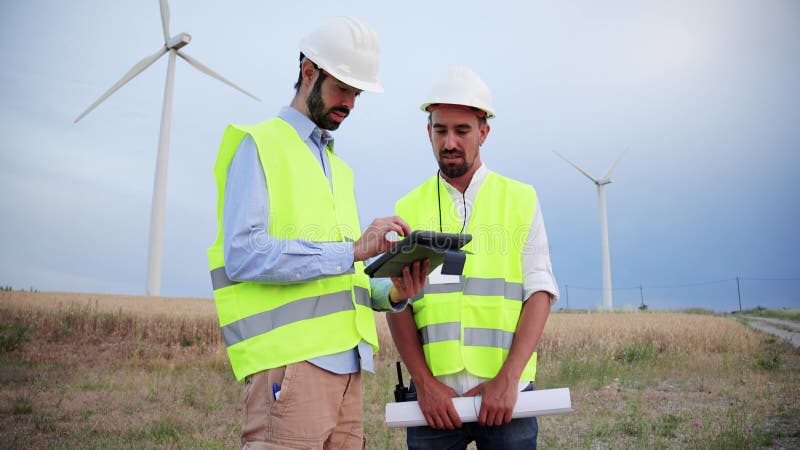 Two Windmill Engineers Using a Tablet Device Inspect the Turbine ...