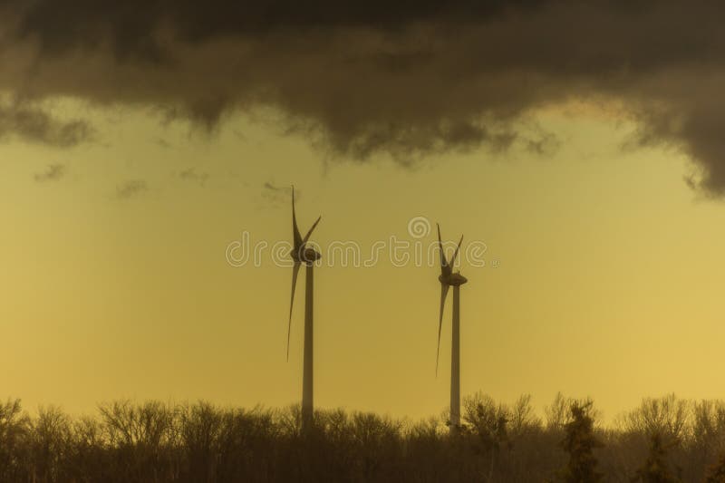 Two Windmills in a Flat Landscape with Dark Rainclouds and Yellow Color ...