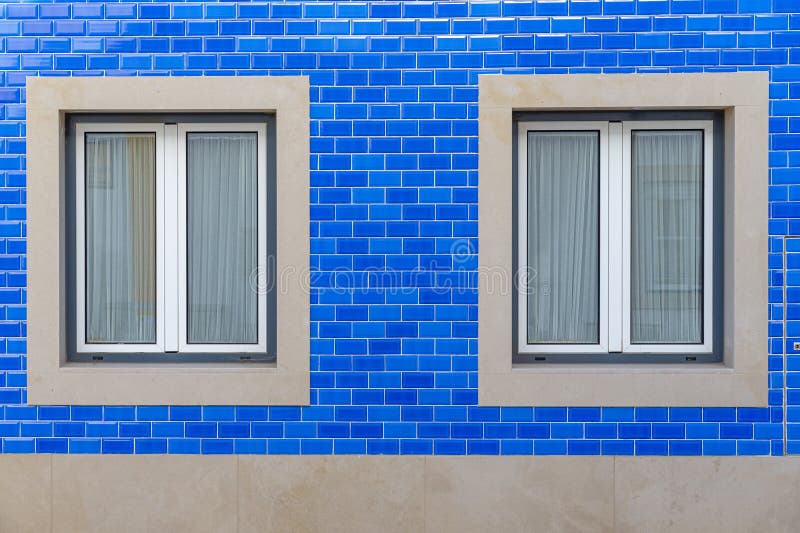 Two Windows on the Facade of a Residence with a Blue Tiled Wall Stock ...