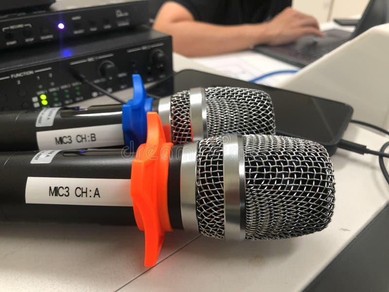 Two Wireless Microphones with Color-coded Windshields Sit on a Table ...