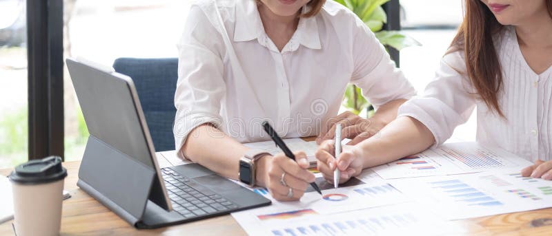 Two Women Analyzing Documents while Sitting on a Table in Office. Woman ...