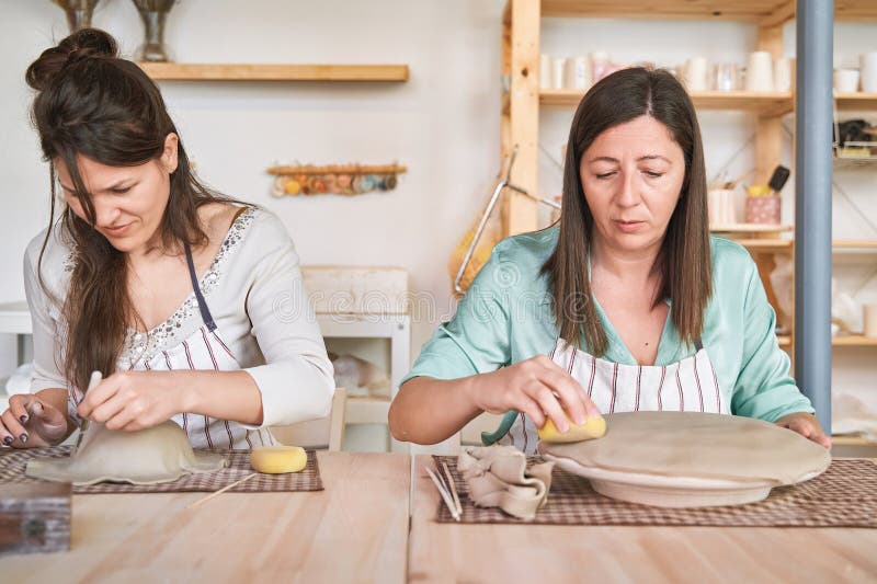 Two Women with Apron Making Pottery Crafts in a Workshop. Stock Photo ...