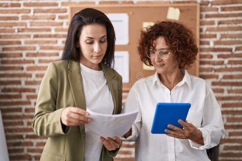 Two Women Business Workers Reading Document Using Touchpad at Office ...