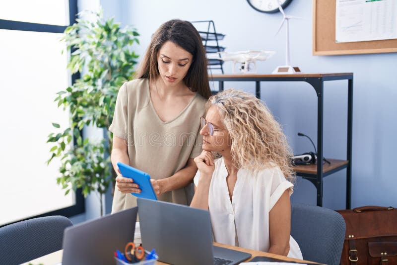 Two Women Business Workers Using Laptop and Touchpad at Office Stock ...