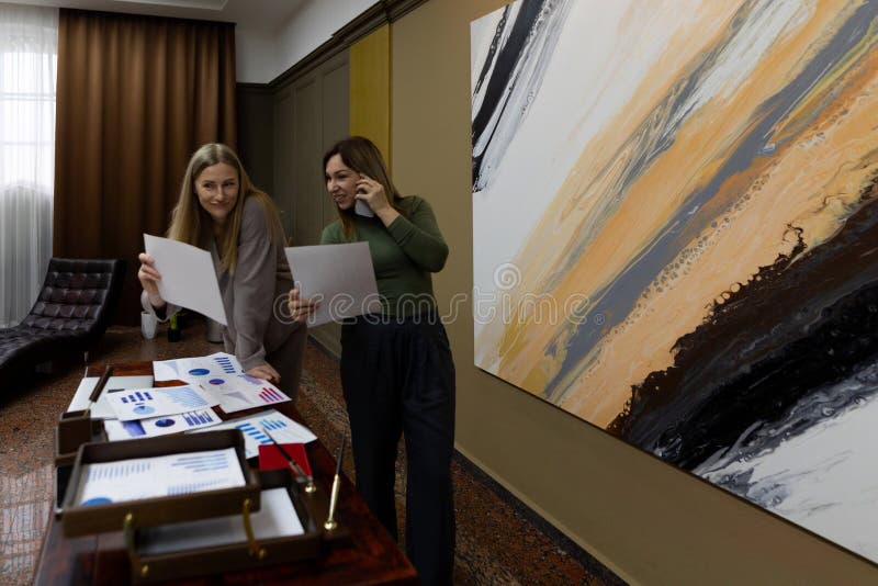 Two Women Collaborating on Design Project in Modern Workspace with ...