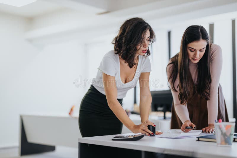 Two Women Collaborating Over Documents in a Bright Office Setting ...