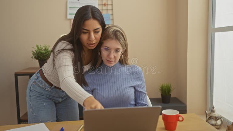 Two Women Collaborating on a Project with a Laptop in a Modern Home ...