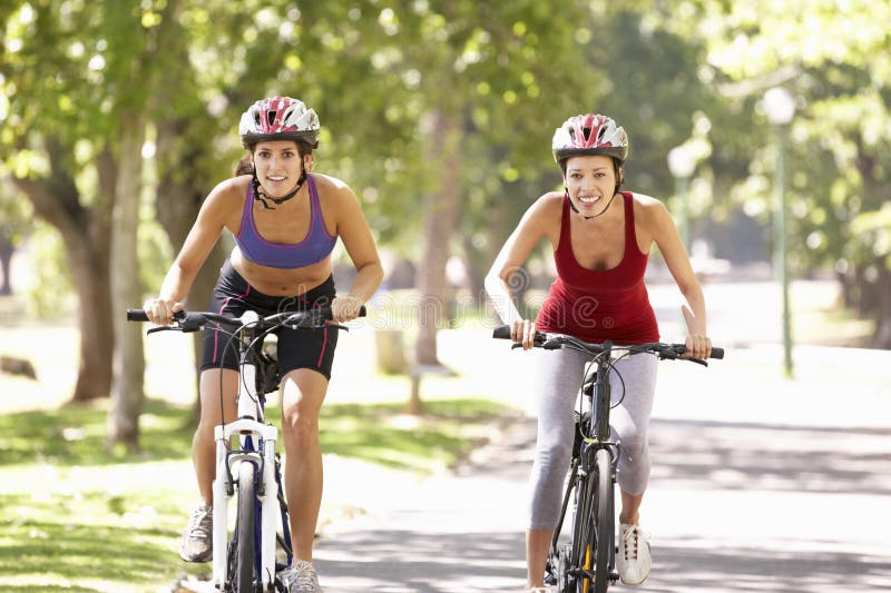 Two Women Cycling through Park Stock Image - Image of healthy, helmet ...