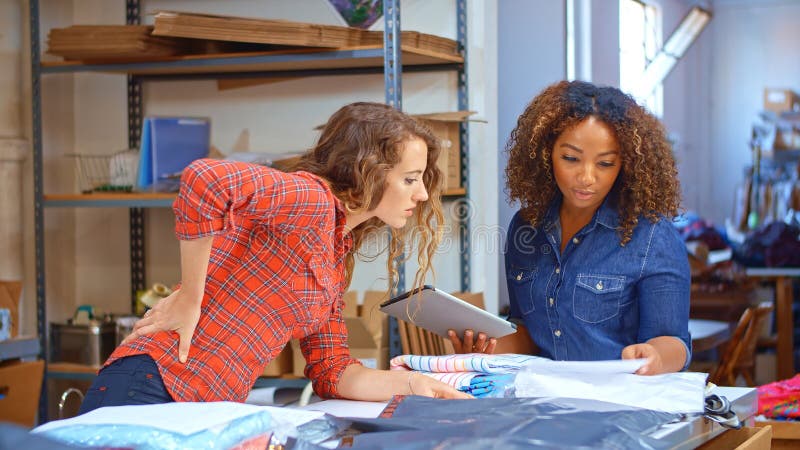 Two Women with Digital Tablet Working in Distribution Warehouse Packing ...