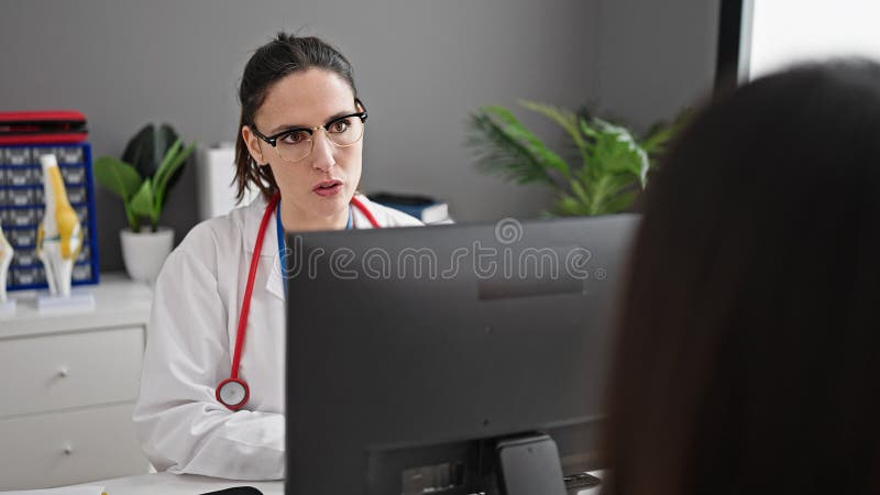 Two Women Doctor and Patient Using Computer Having Consultation at ...