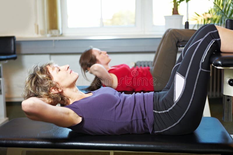 Two women doing sit-ups stock photo. Image of muscle - 17214814