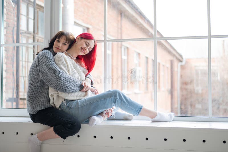 Portrait Of Two Tenderly Hugging Women Dressed In Sweaters Lesbian