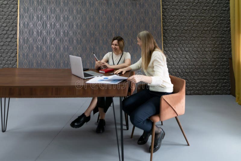 Women Collaborating at a Modern Workspace during a Casual Meeting in a ...