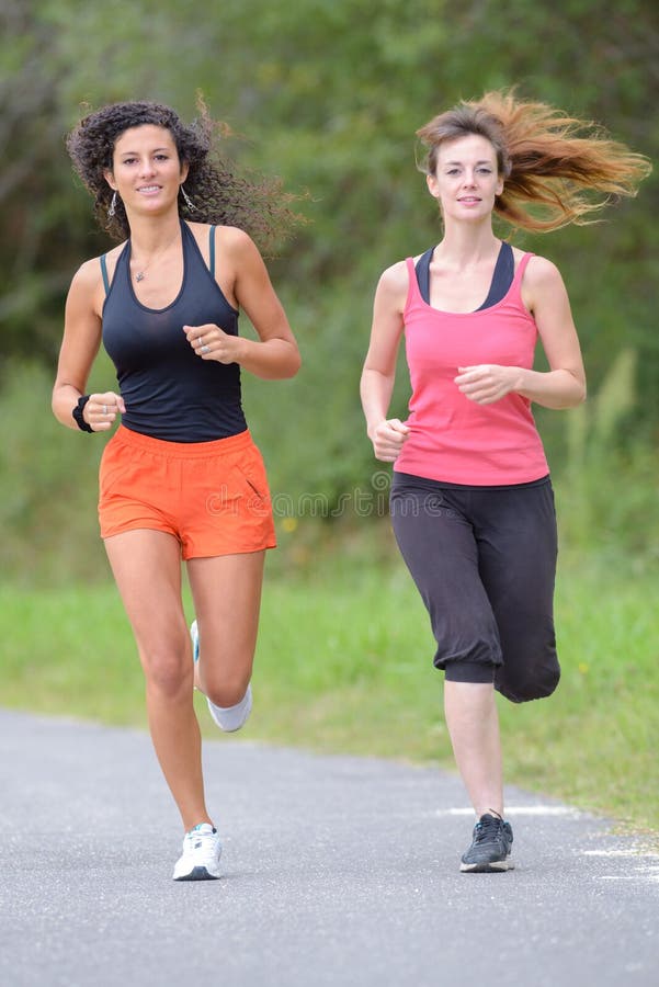 Two women jogging outdoors stock image. Image of recreation - 196685453