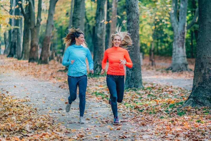 Two Women Jogging Outdoors in a Park in the Fall Stock Image - Image of ...