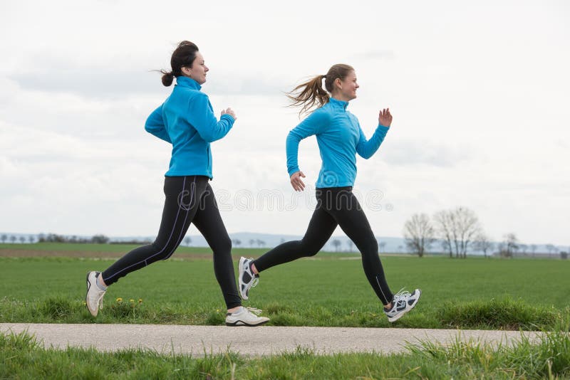 Two women jogging outdoors stock image. Image of running - 70319009