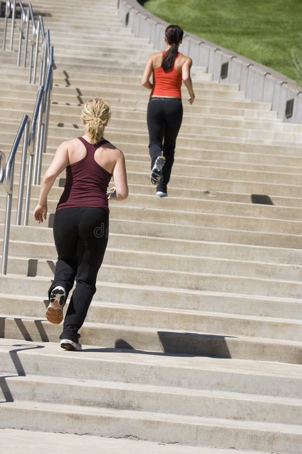 Two women jogging up steps stock image. Image of effort - 5400753