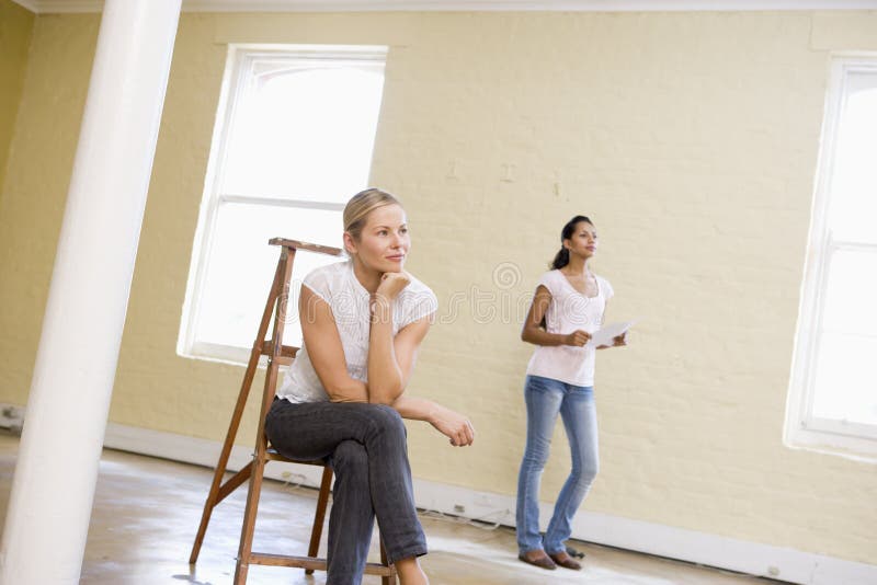 Two Women with Ladder in Empty Space Holding Paper Stock Image - Image ...