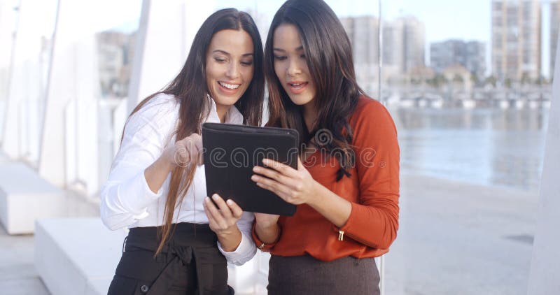 Two Women Laughing at a Tablet Computer Stock Photo - Image of woman ...