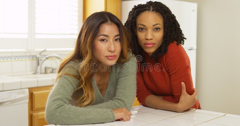 Two Women Leaning Against Kitchen Counter Looking at Camera Stock Image ...