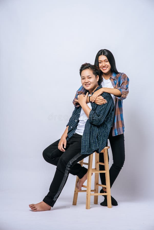 Two Women Lovers Grab Another Shoulder and Sit in a Chair Stock Photo ...