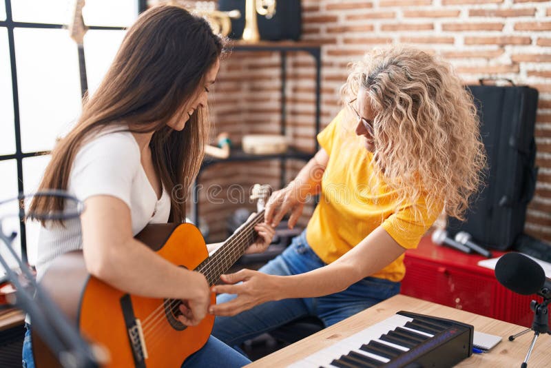 Two Women Musicians Having Classical Guitar Lesson at Music Studio ...