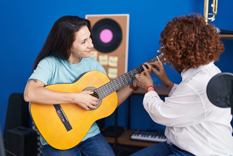 Two Women Musicians Having Classical Guitar Lesson at Music Studio ...