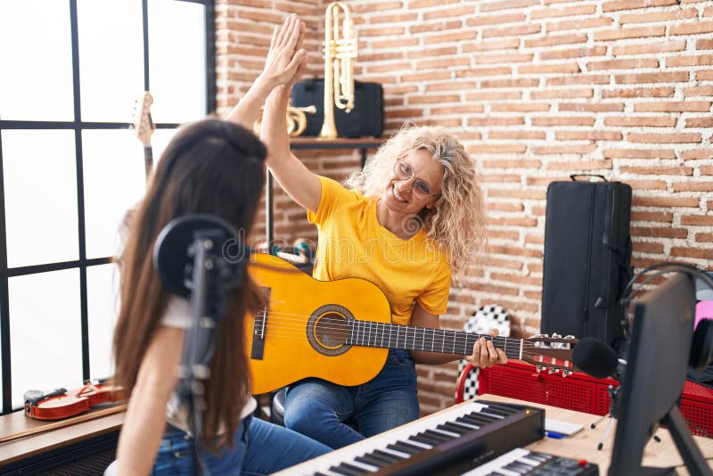 Two Women Musicians High Five with Hands Raised Up at Music Studio ...