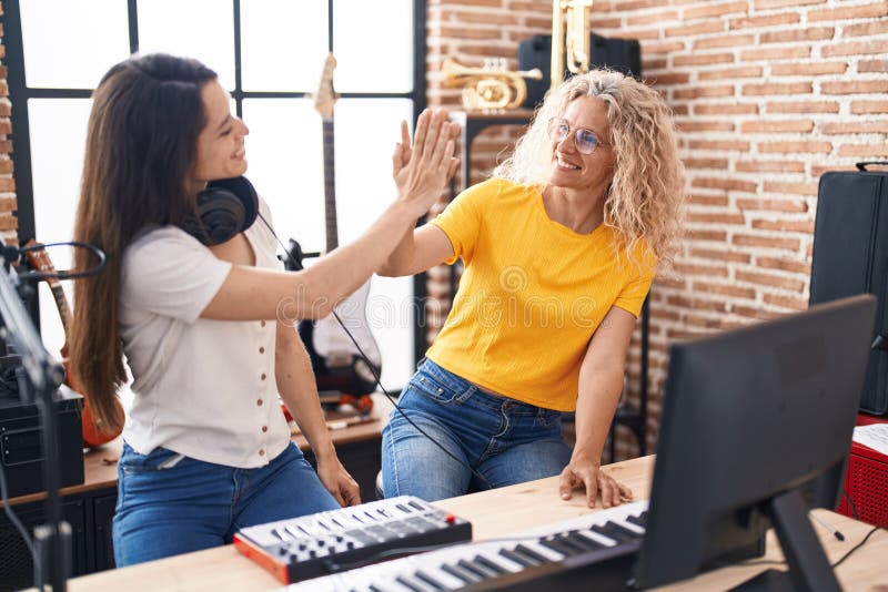 Two Women Musicians High Five with Hands Raised Up at Music Studio ...