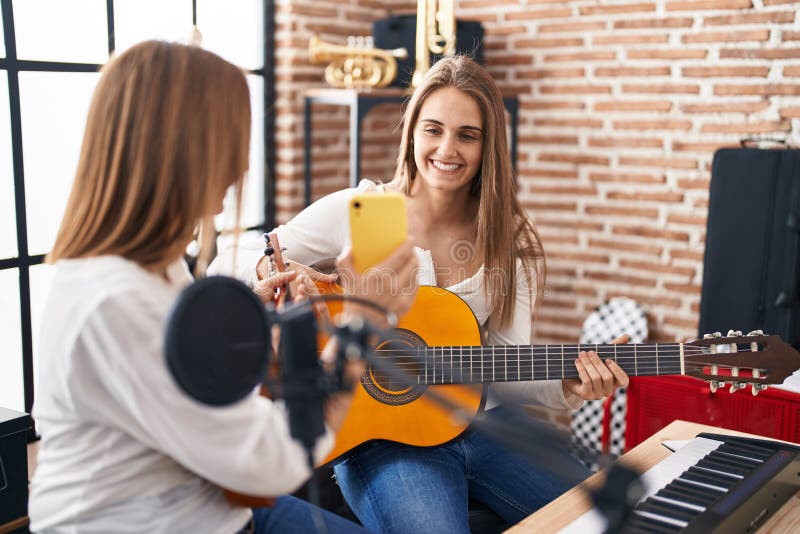 Two Women Musicians Playing Classical Guitar Looking Smartphone at ...