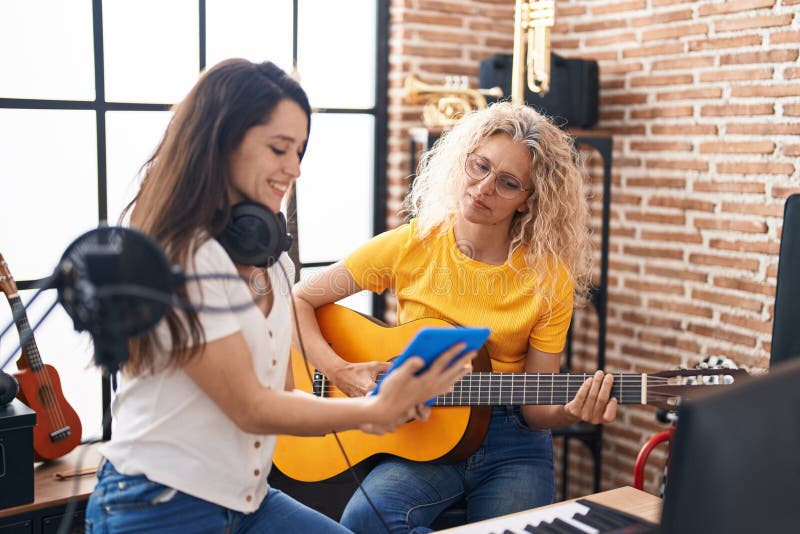 Two Women Musicians Playing Classical Guitar Looking Touchpad at Music ...