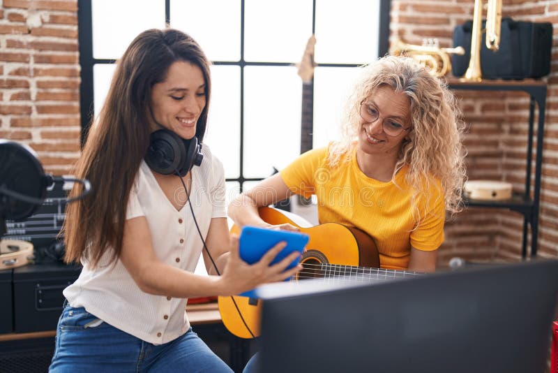 Two Women Musicians Playing Classical Guitar Looking Touchpad at Music ...