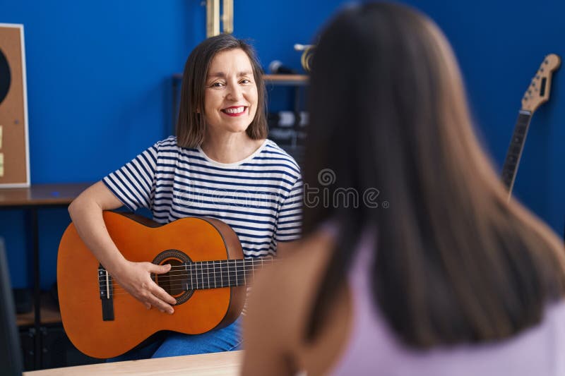 Two Women Musicians Playing Classical Guitar at Music Studio Stock ...
