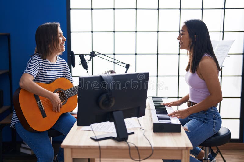 Two Women Musicians Playing Classical Guitar and Piano at Music Studio ...