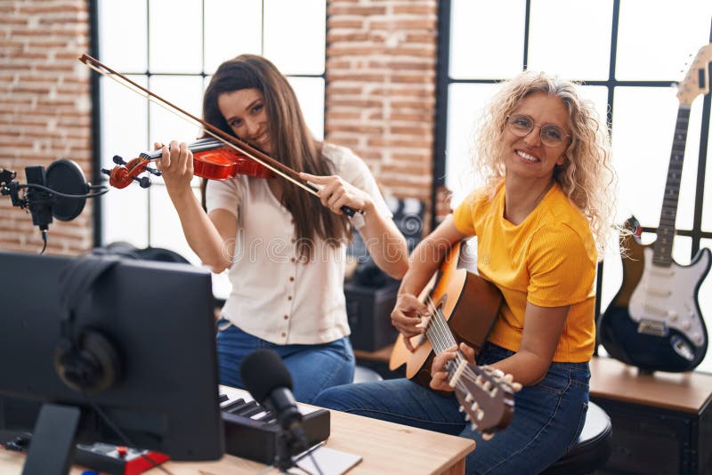 Two Women Musicians Playing Violin and Classical Guitar at Music Studio ...