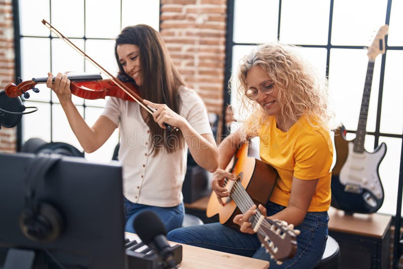 Two Women Musicians Playing Violin and Classical Guitar at Music Studio ...