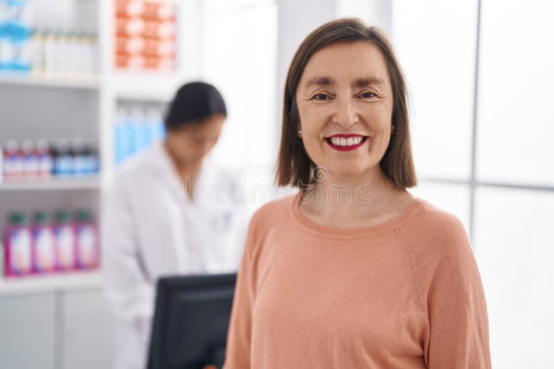 Two Women Pharmacist and Customer Smiling Confident at Pharmacy Stock ...