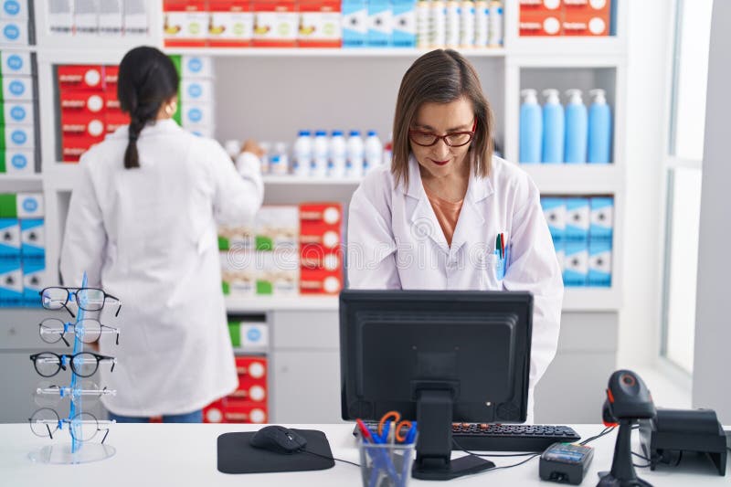 Two Women Pharmacist Using Computer Working at Pharmacy Stock Image ...