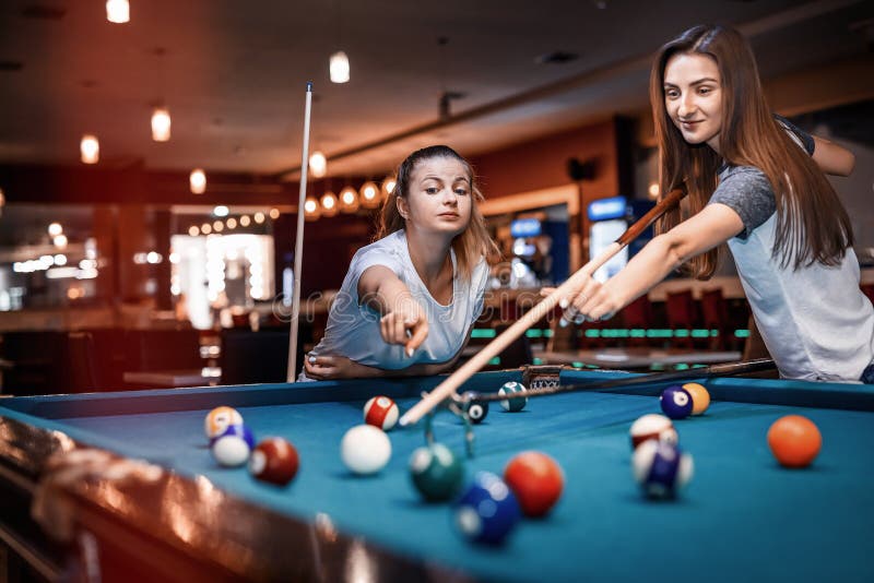 Two Women Playing Billiard Using Cue Rack Stock Image - Image of friend ...