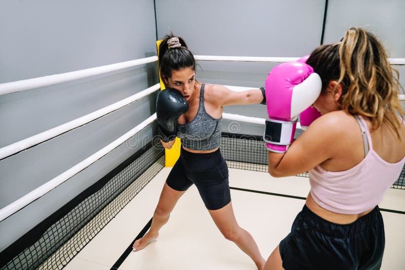Two Women Practicing Punches in a Kickboxing Practice in the Ring Stock ...