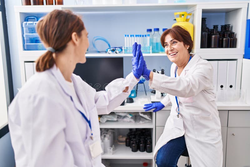 Two Women Scientist Smiling Confident High Five with Hands Raised Up at ...