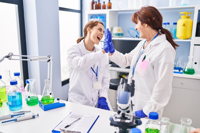 Two Women Scientist Smiling Confident High Five with Hands Raised Up at ...