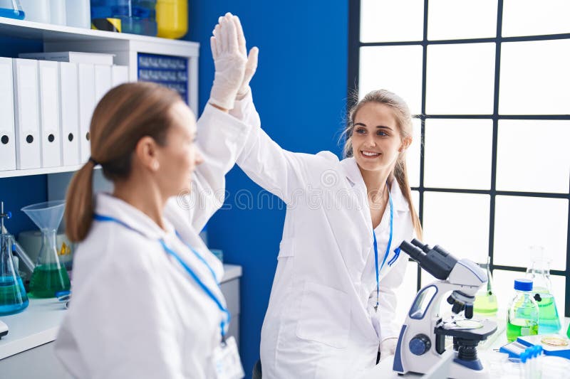 Two Women Scientists High Five with Hands Raised Up at Laboratory Stock ...