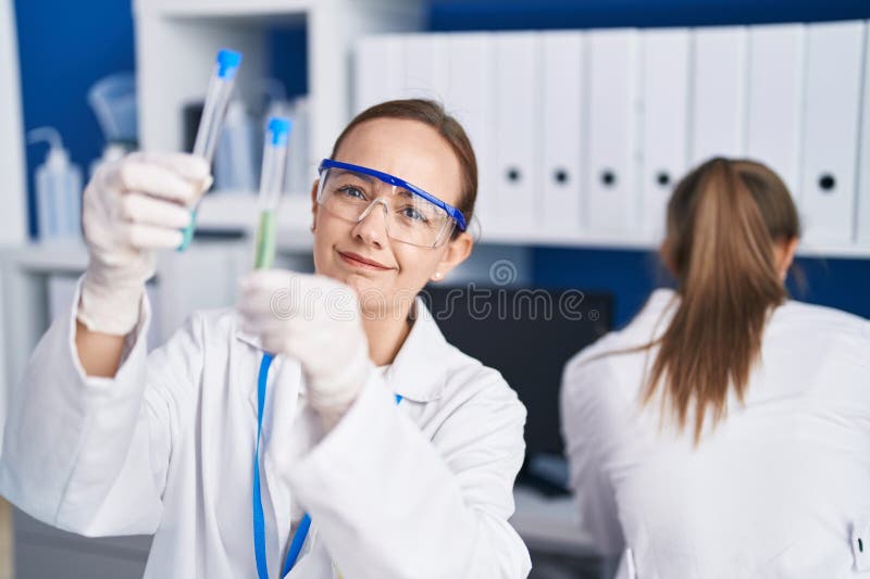 Two Women Scientists Smiling Confident Holding Test Tubes at Laboratory ...